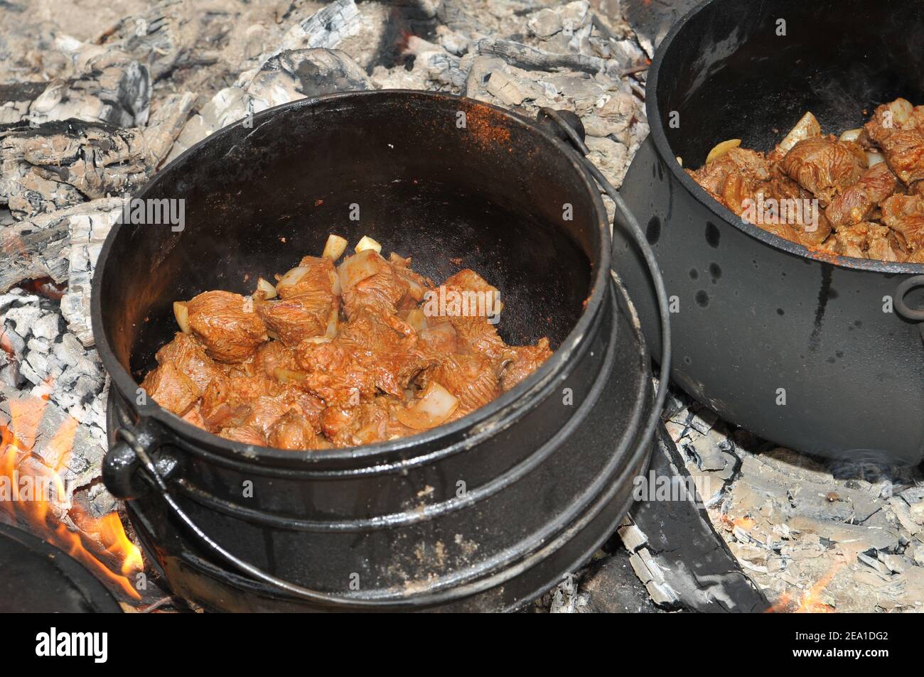 The appetizing meat pieces being cooked in an old black metal pot Stock ...