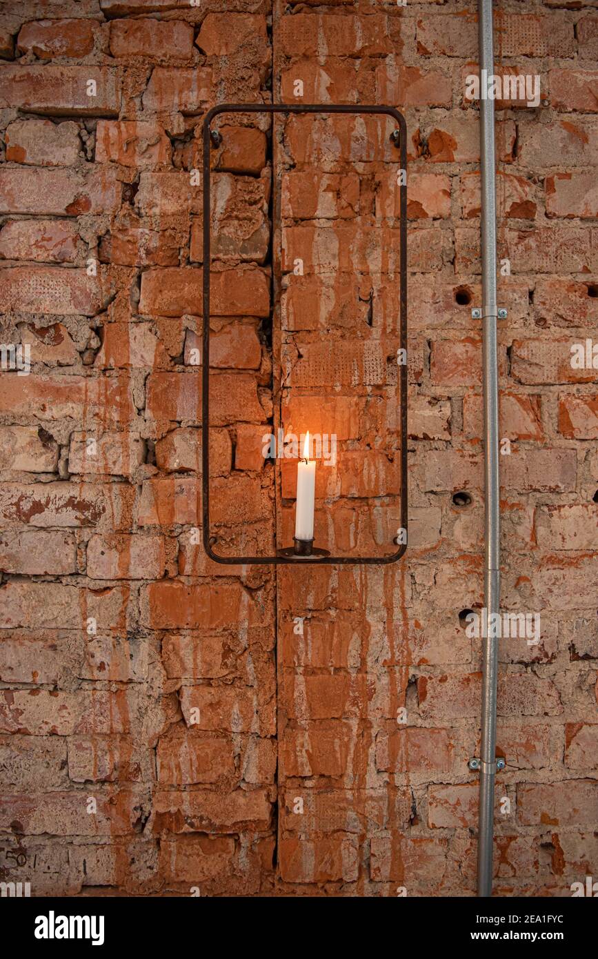 Candle light on a minimalistic holder on a red brick wall Stock Photo ...