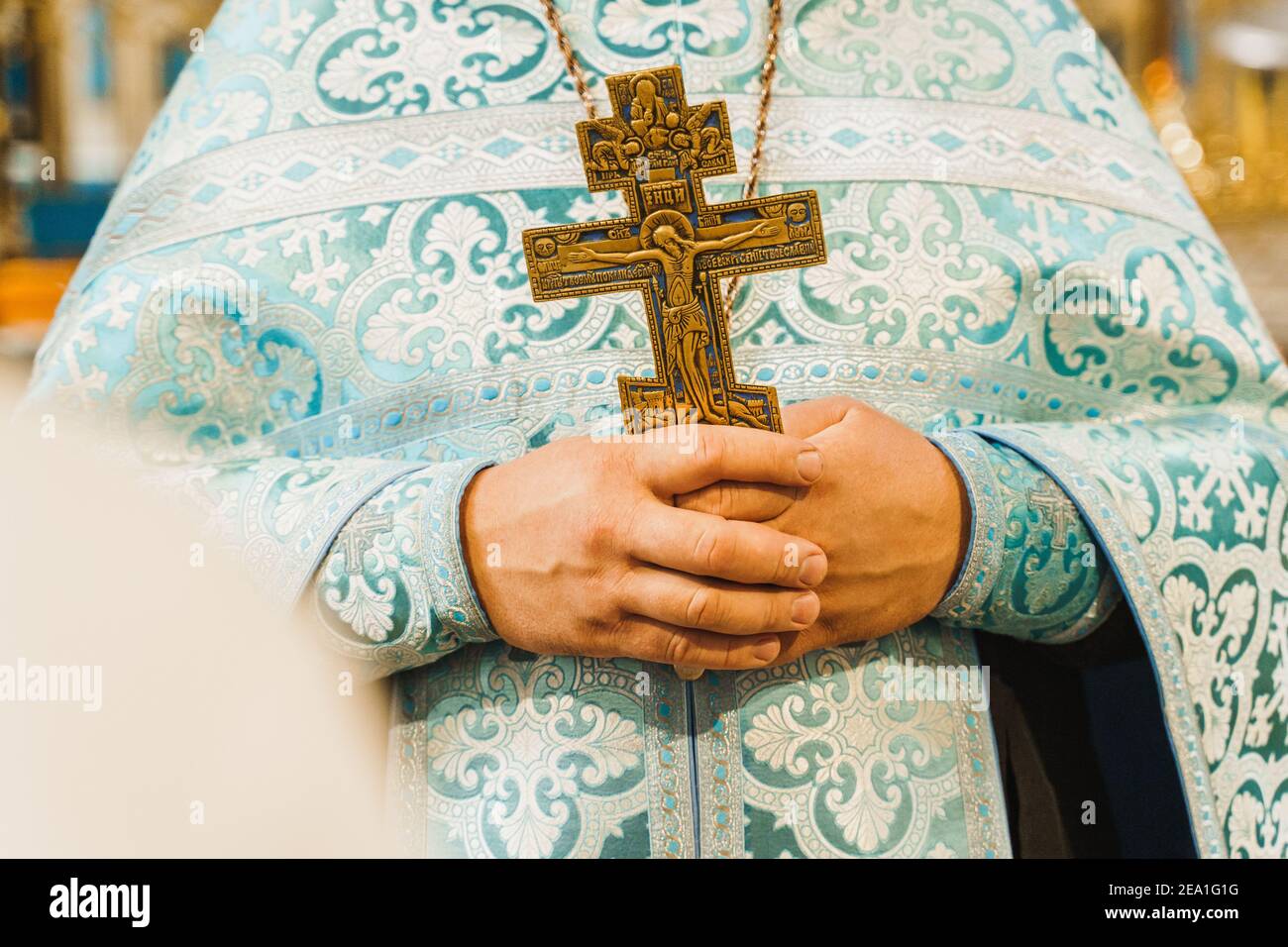 Holy father in his robe with a golden cross in his hands in church ...
