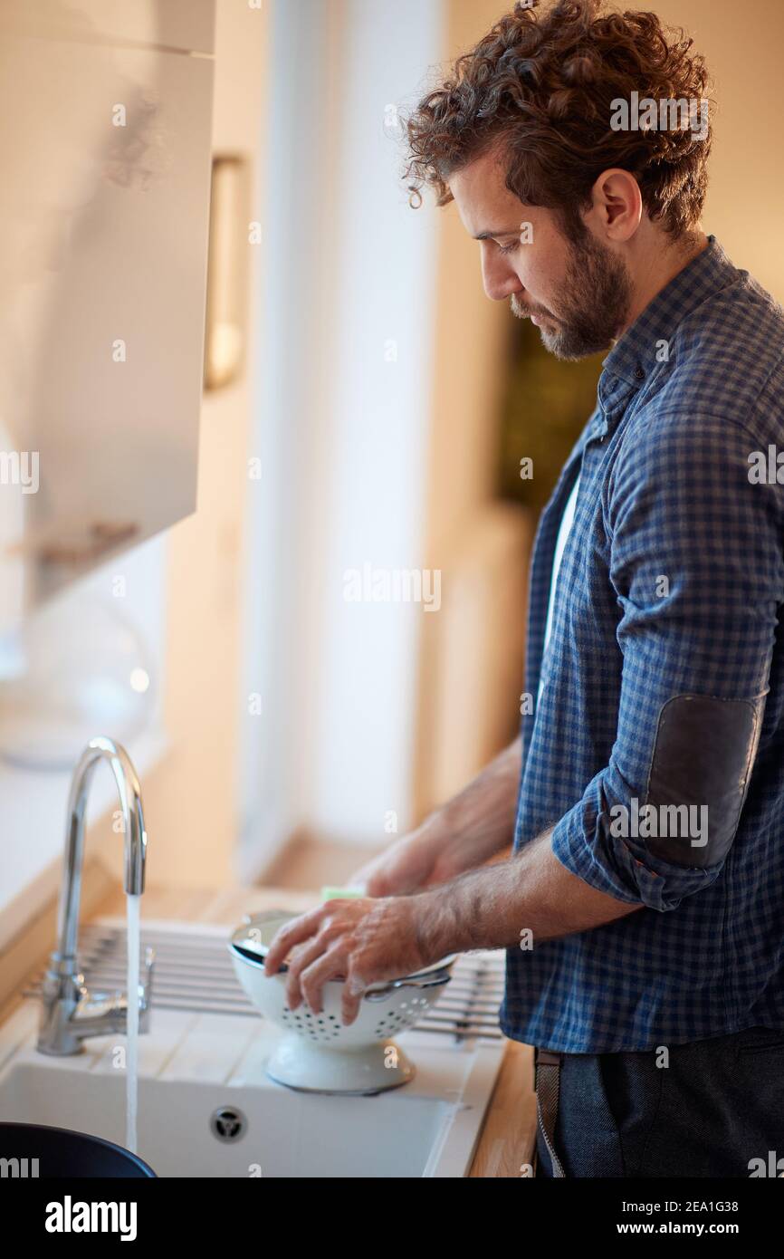 Man washing dishes in kitchen hi-res stock photography and images - Alamy