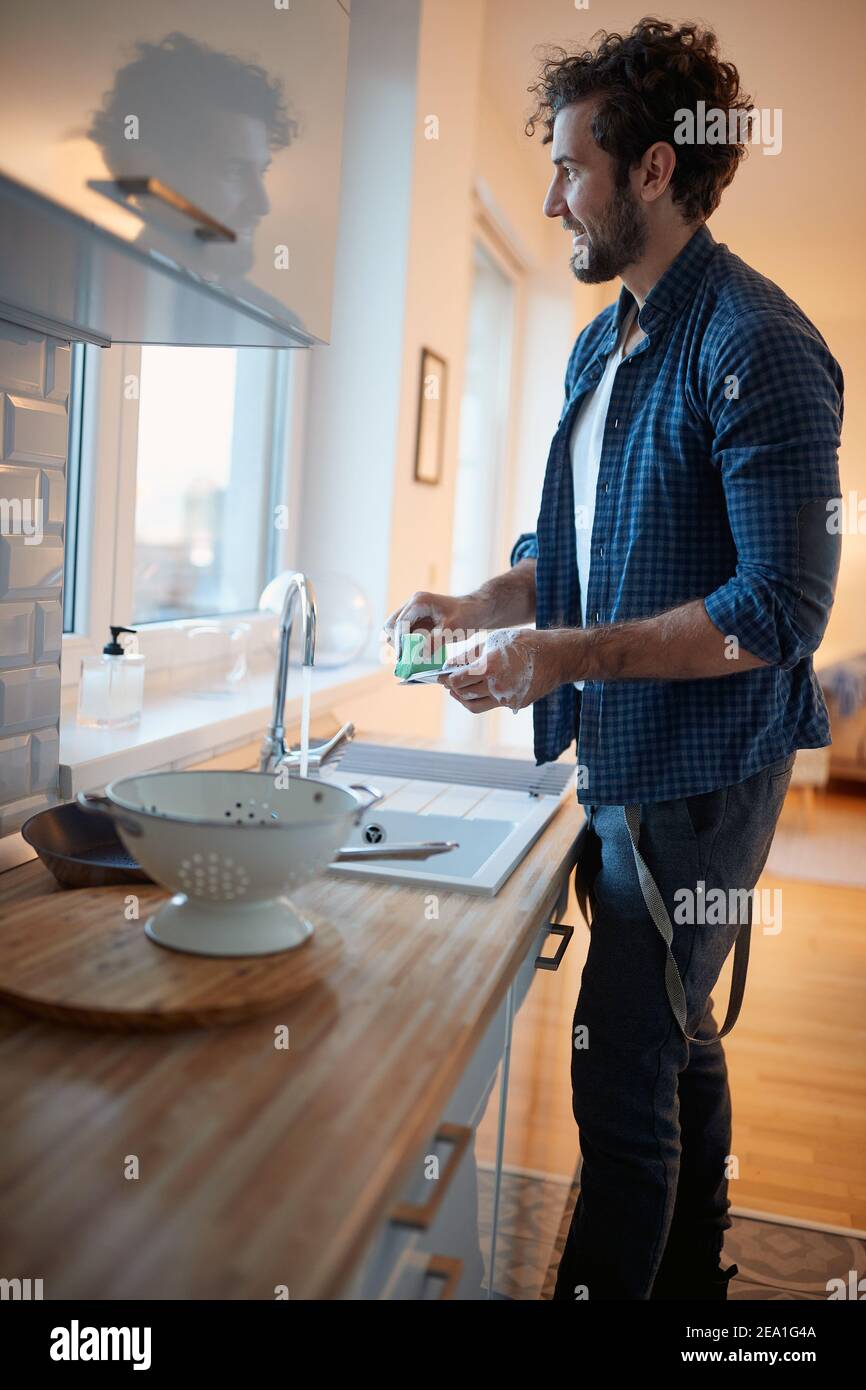 Handsome guy doing housework in hi-res stock photography and images - Alamy