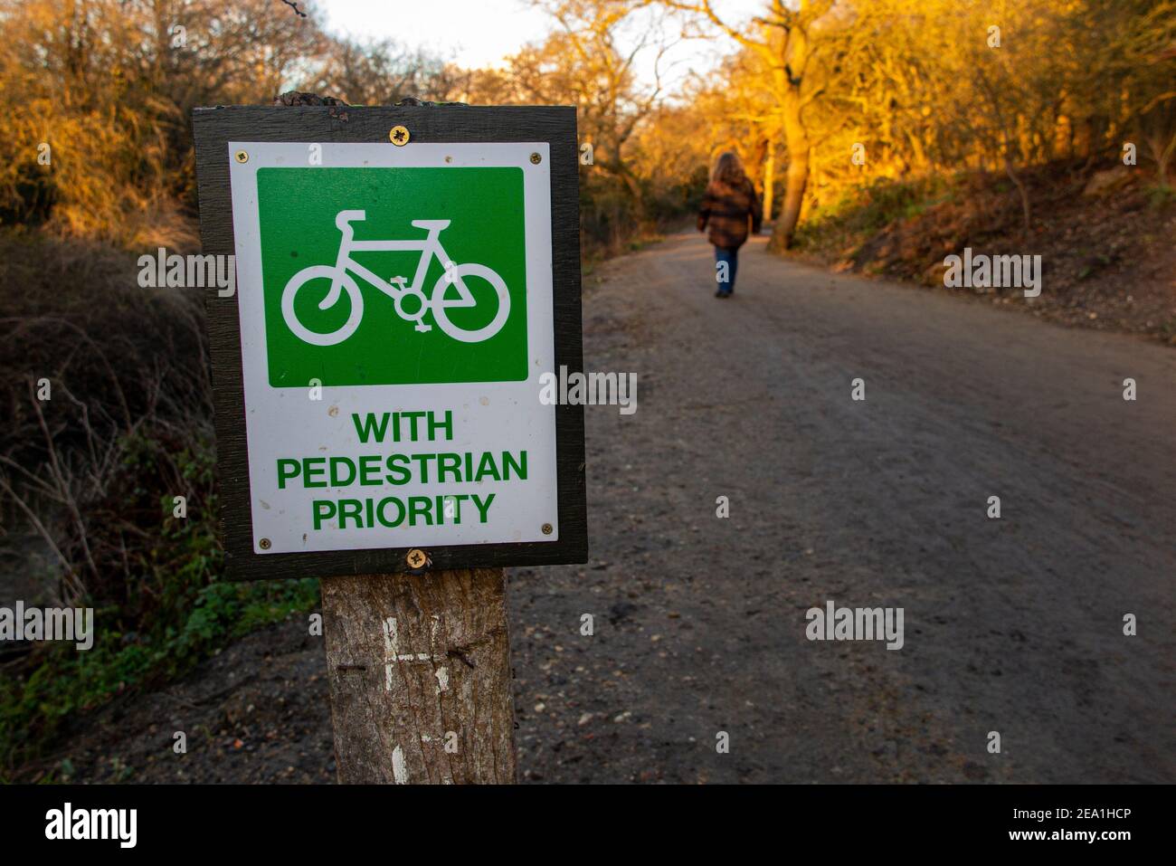Cycling allowed with pedestrian priority sign in a wooded area of a ...