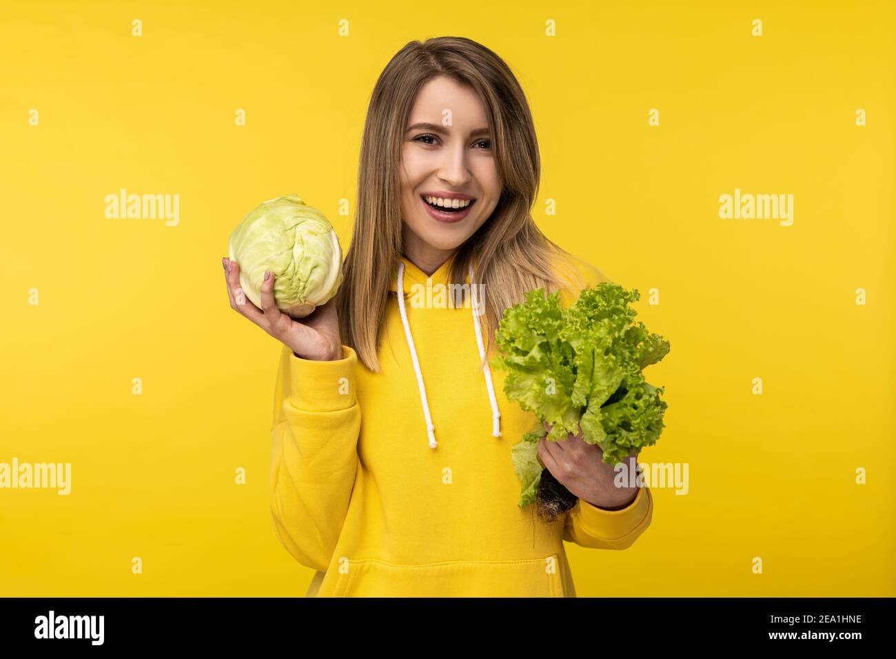 Photo of attractive lady holds cabbage and salad, happy about healthy ...