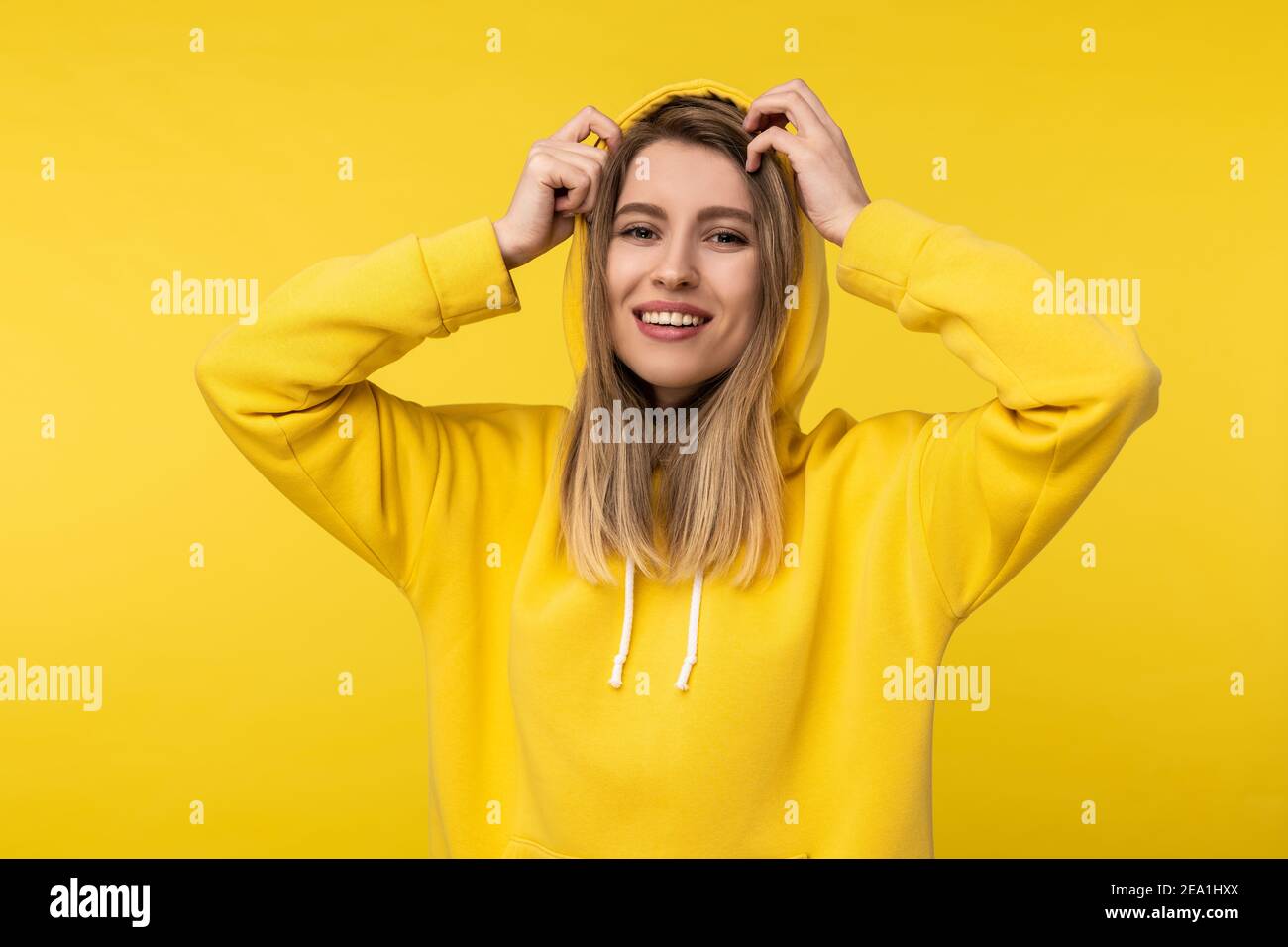 Photo of attractive lady in the hood poses in a cute way. Wears casual ...