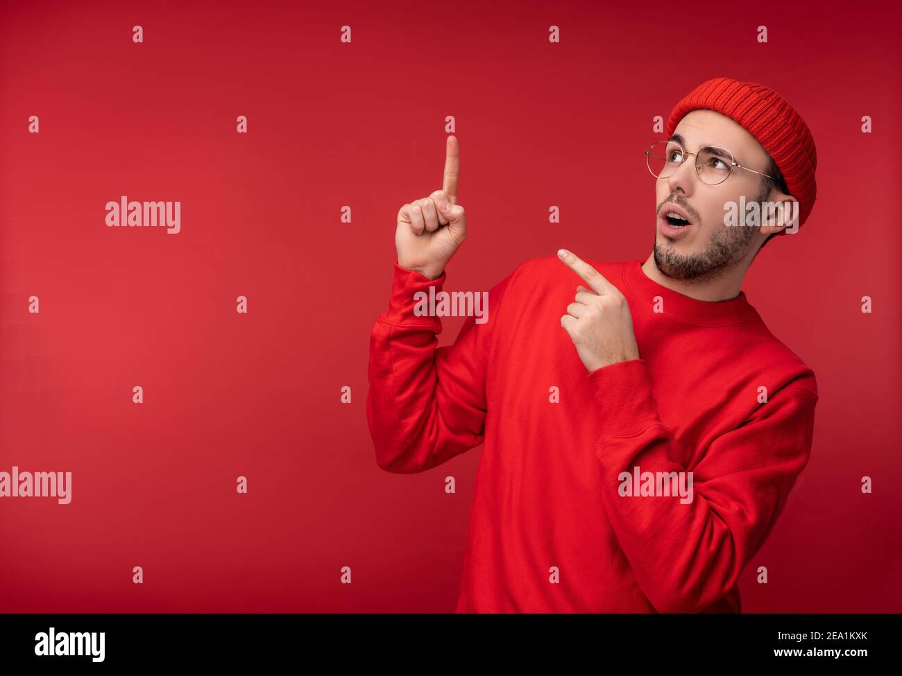 Photo of attractive man with beard in glasses and red clothing. Shocked ...