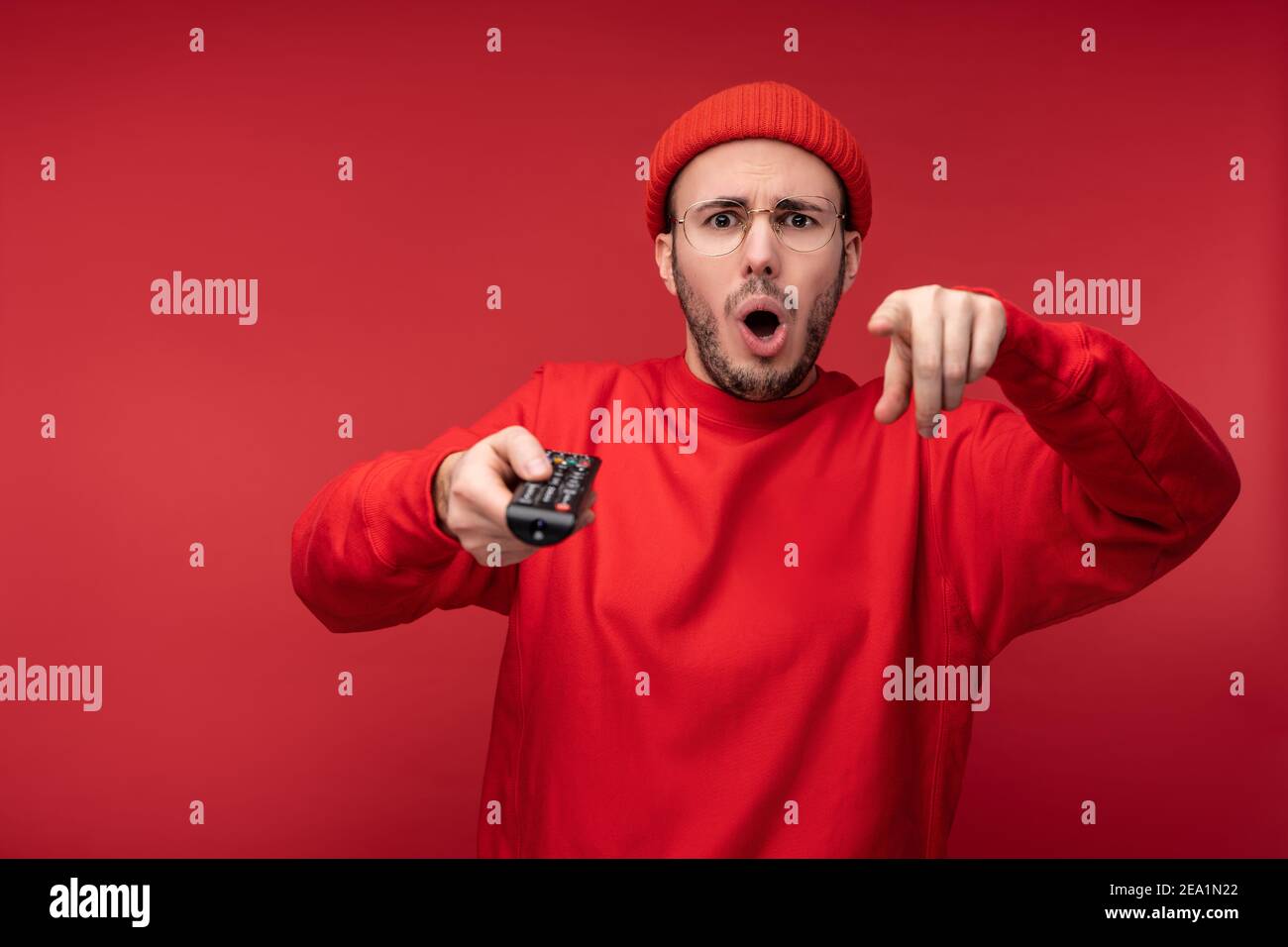 Photo of agitated man wih beard in red clothing pointing fingers at ...