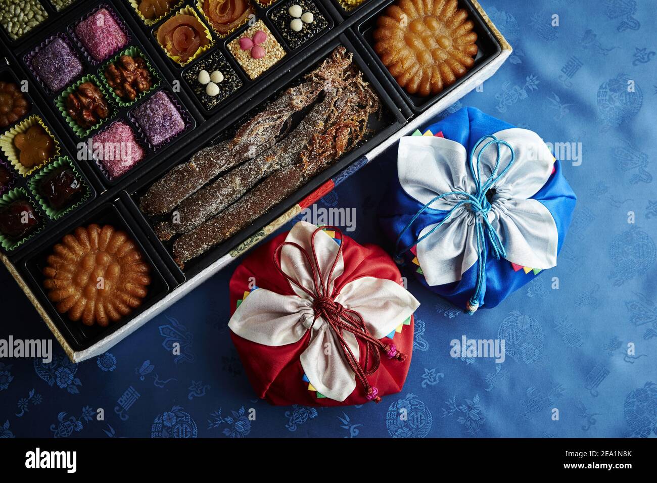A top view of a box full of Korean sweets, surrounded by colorfully ...