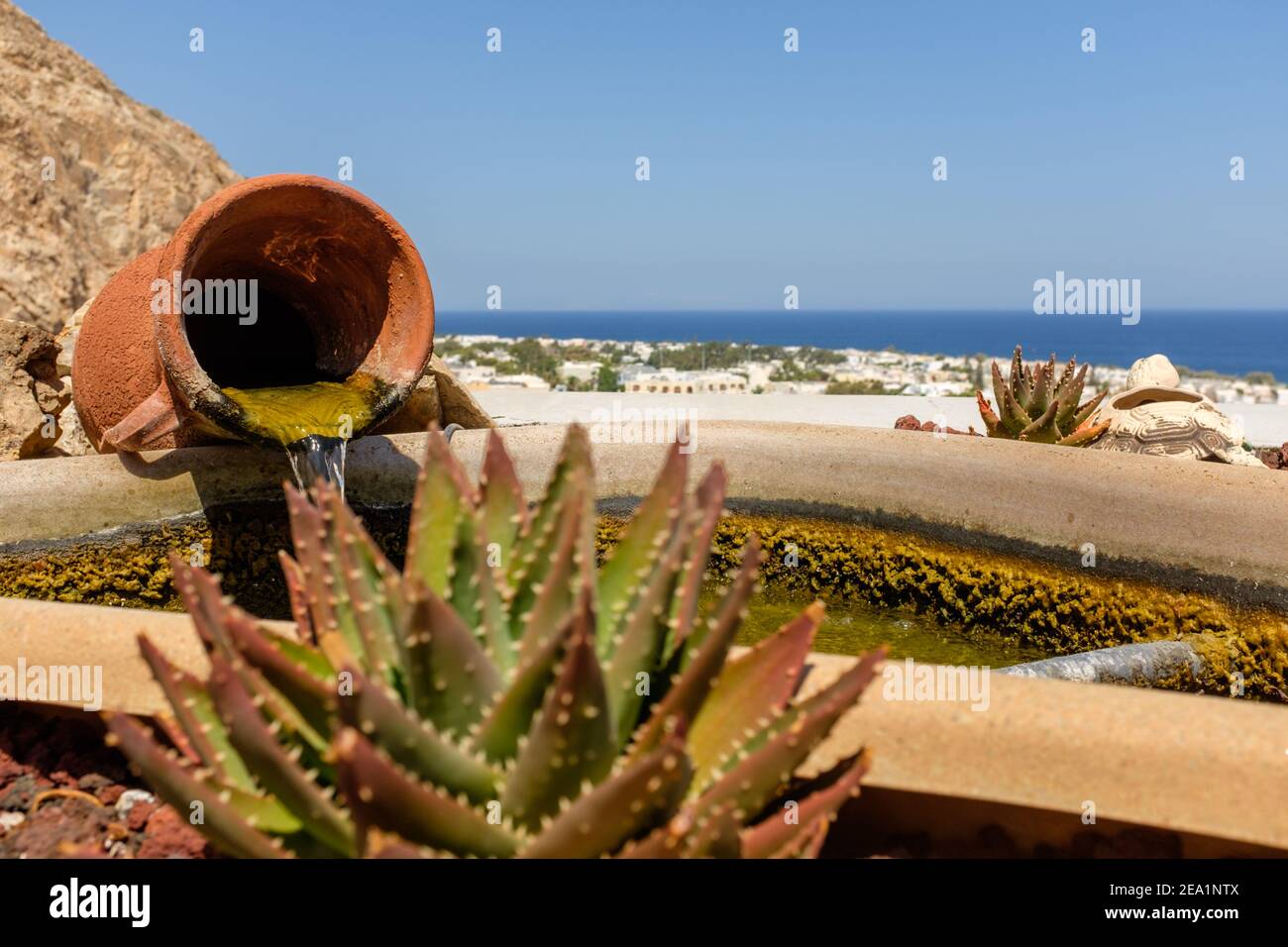 Water feature overlooking the Aegean Sea on the island of Santorini ...