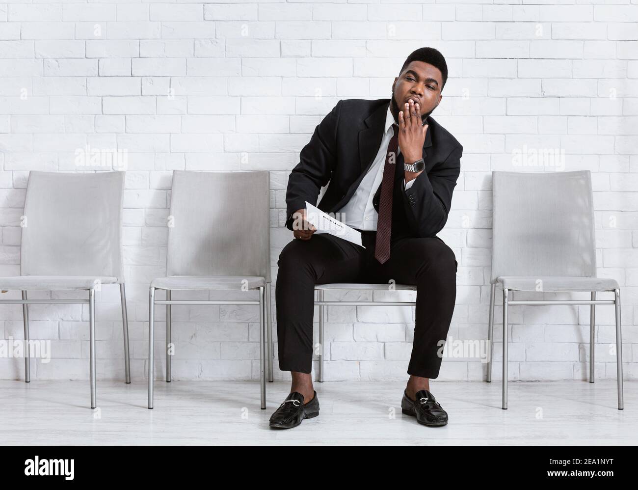 Headhunting and personnel recruiting. Bored black guy with CV yawning ...