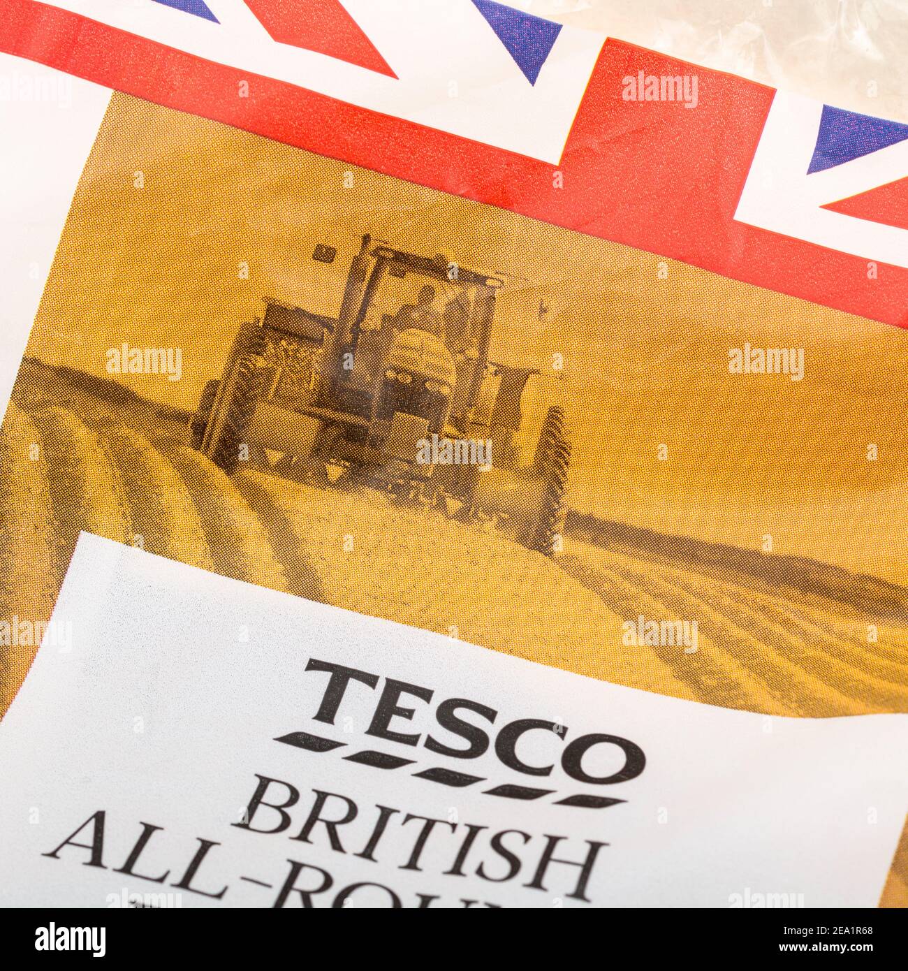 Close-up shot of tractor ploughing field and Union Jack on the ...