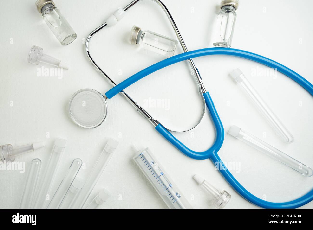 Medical layout on white background, flat lay. Blue stethoscope or phonendoscope surrounded by ...