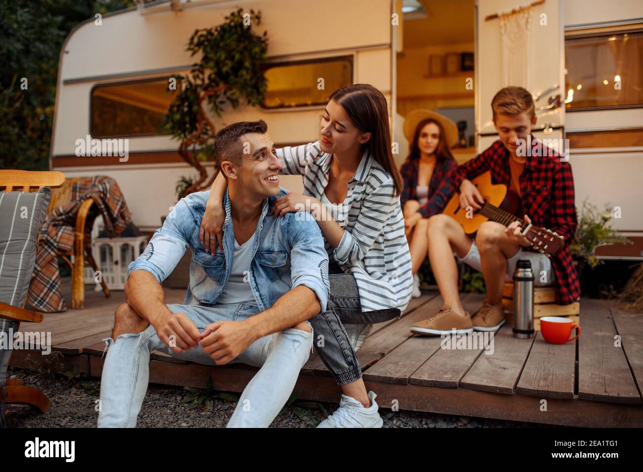 Happy friends resting near rv on picnic at camping Stock Photo - Alamy