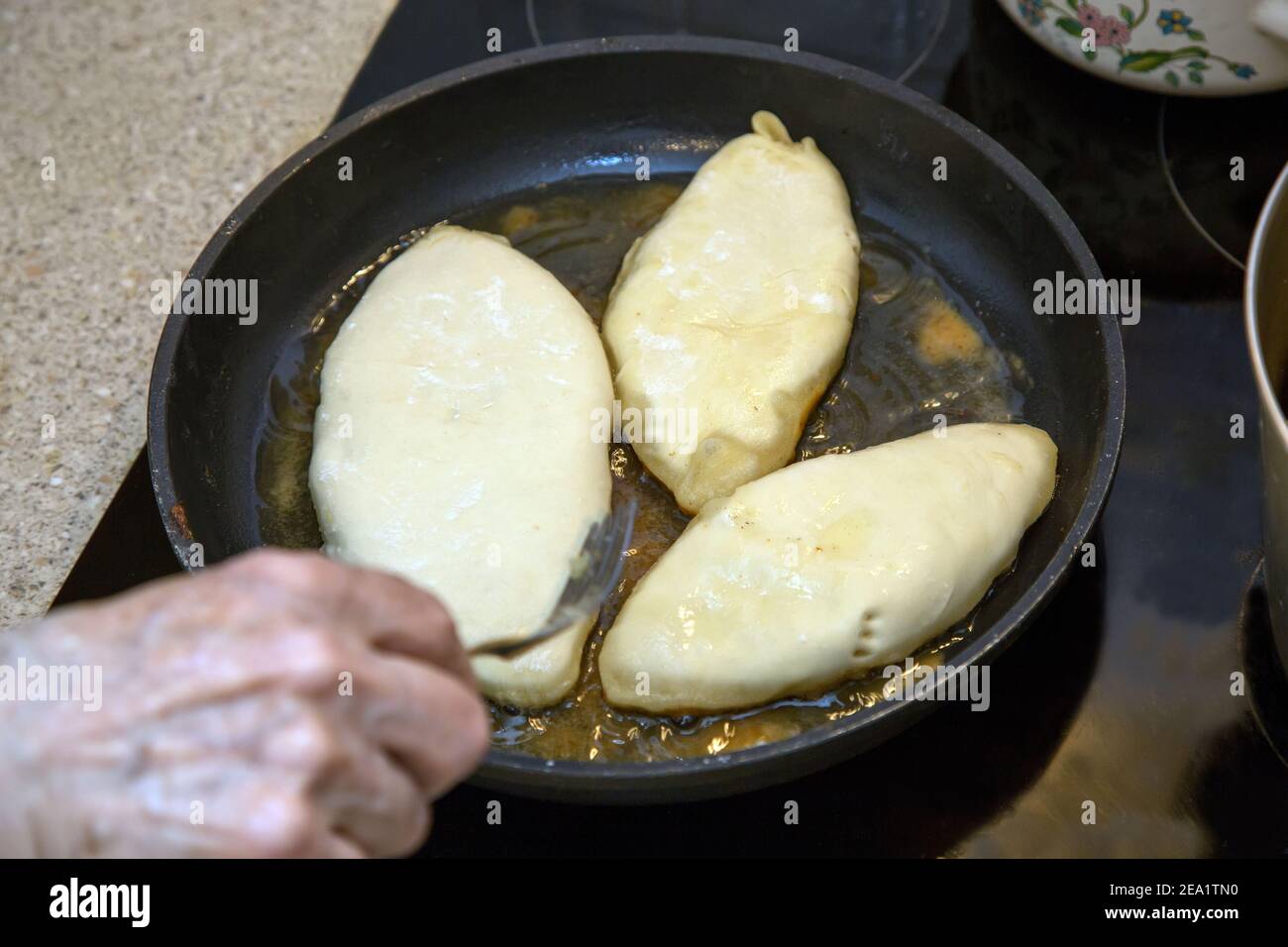 Female hand turns hot cakes in a pan with a fork Stock Photo - Alamy