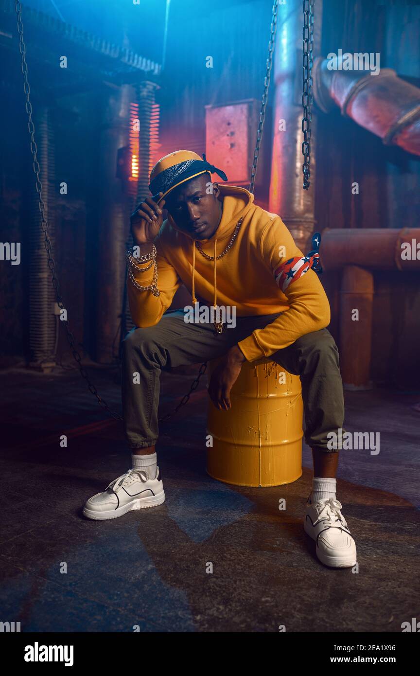 Rapper in yellow hoodie poses in studio Stock Photo - Alamy