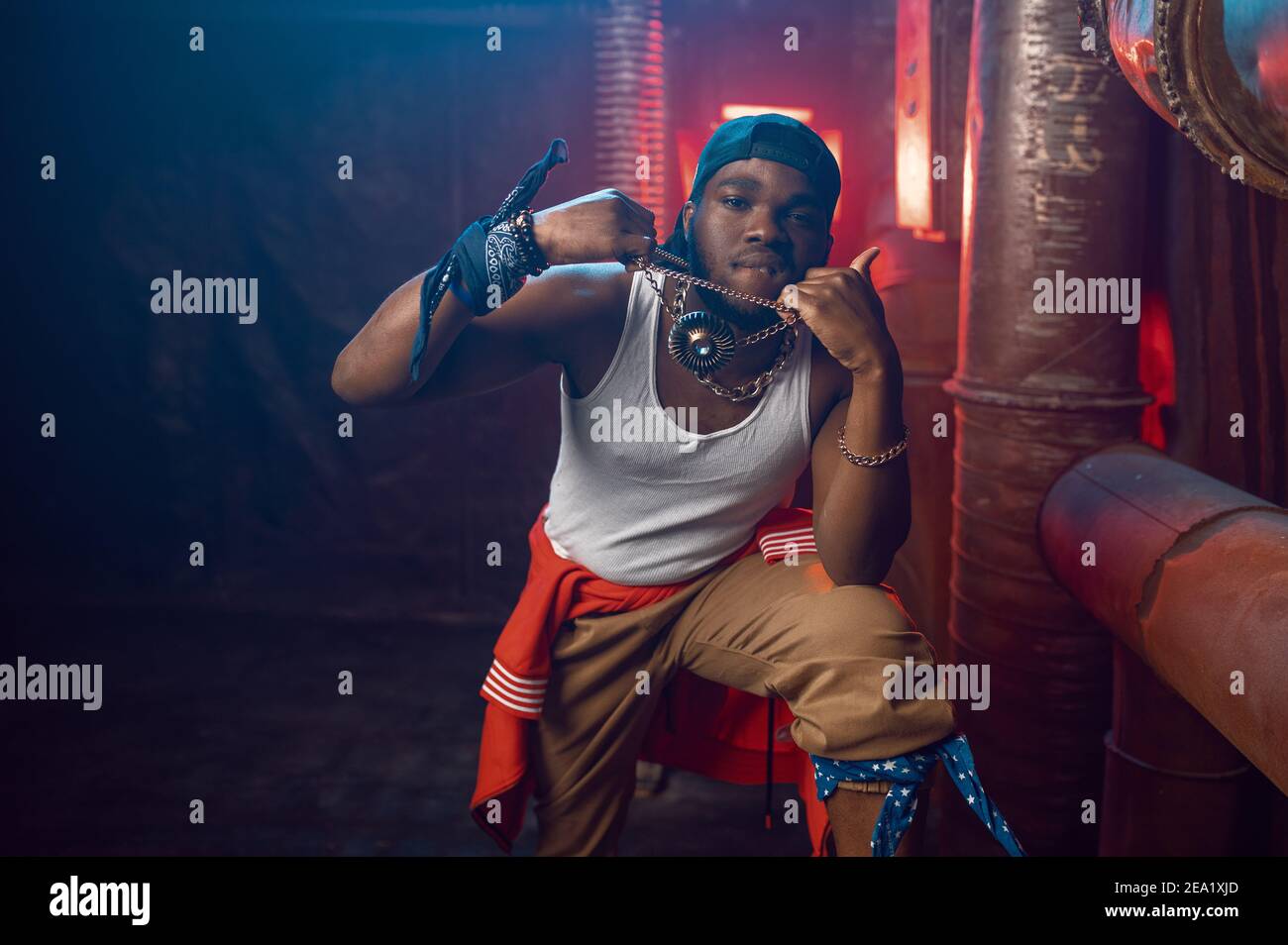 Stylish rapper shows his gold jewelry in studio Stock Photo - Alamy