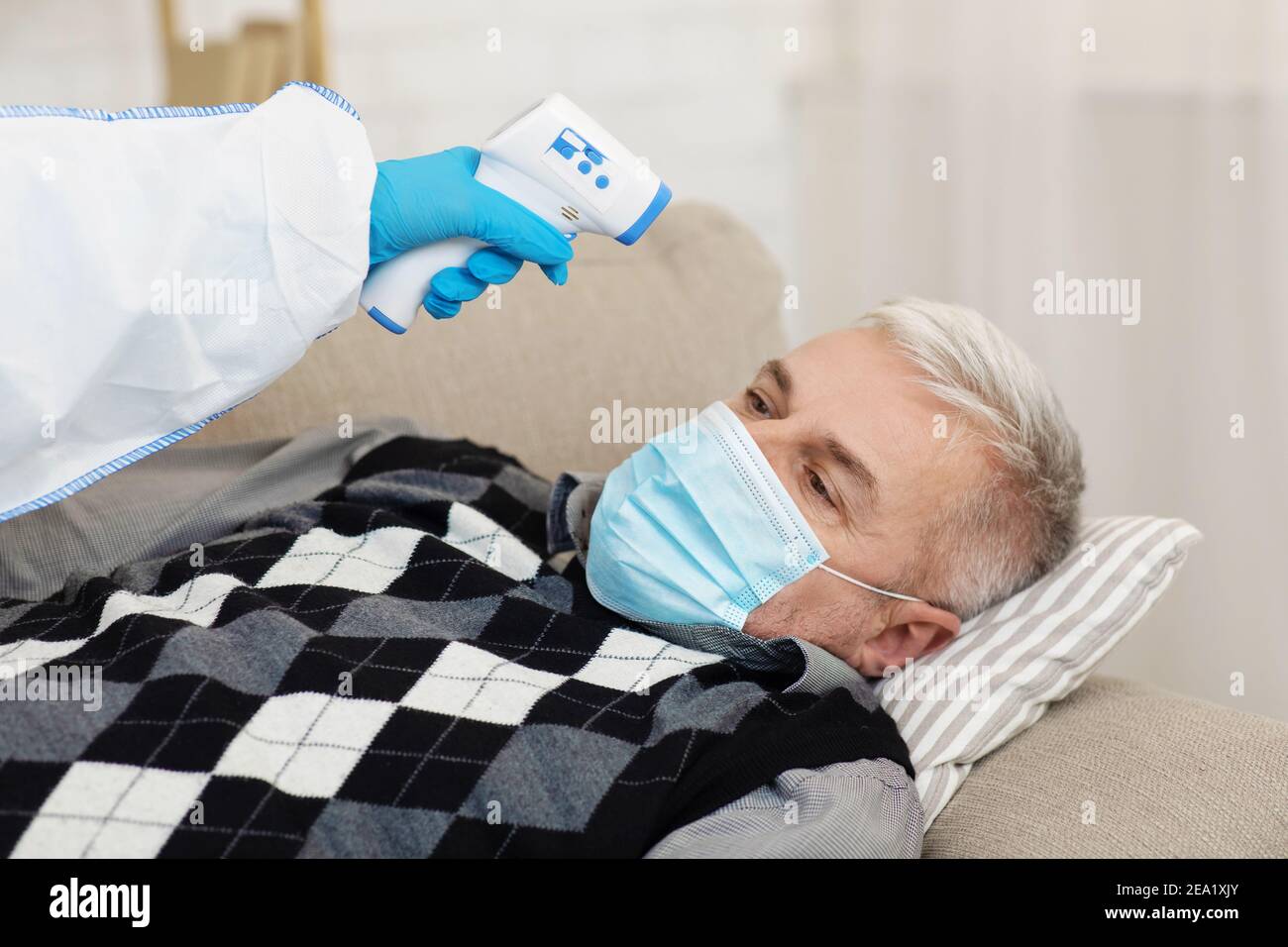Doctor in hazmat suit measures temperature with modern contactless ...