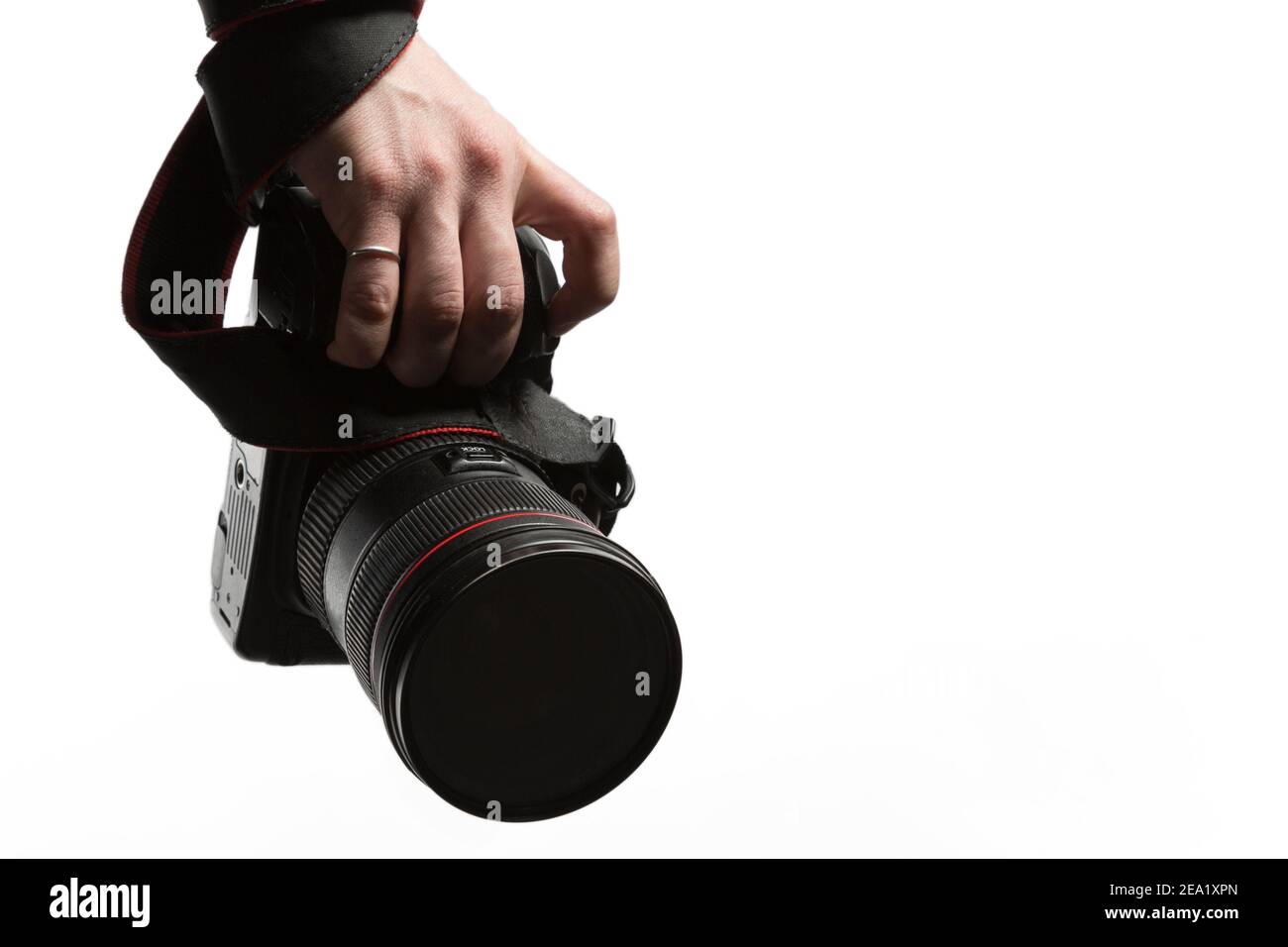 a man with a ring on his finger holding in the hand a DSLR camera close ...