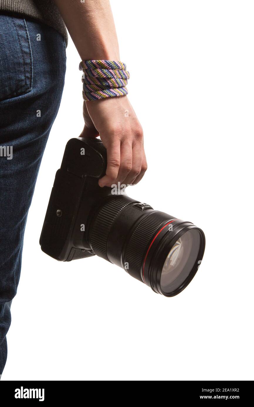 a teenager holds in her hand a DSLR camera. Isolated on white ...