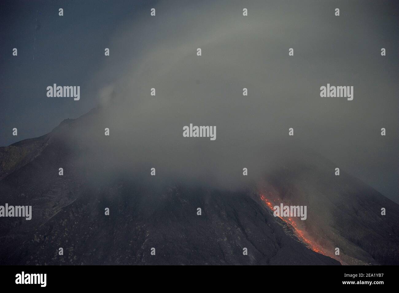 Lava seen flowing from the crater of Sinabung volcano while during ...