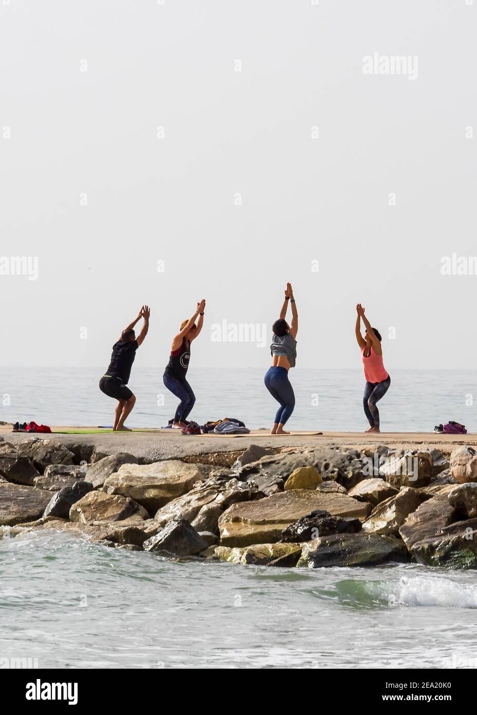 Group of people doing gymnastic exercises on some rocks in front of the ...
