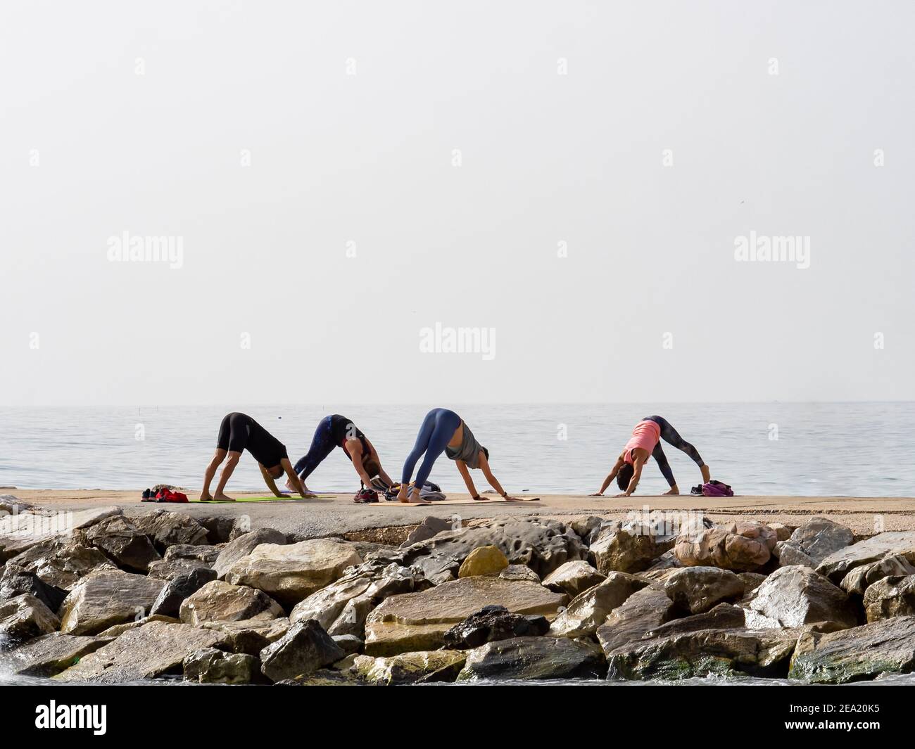 Group of people doing gymnastic exercises on some rocks in front of the ...