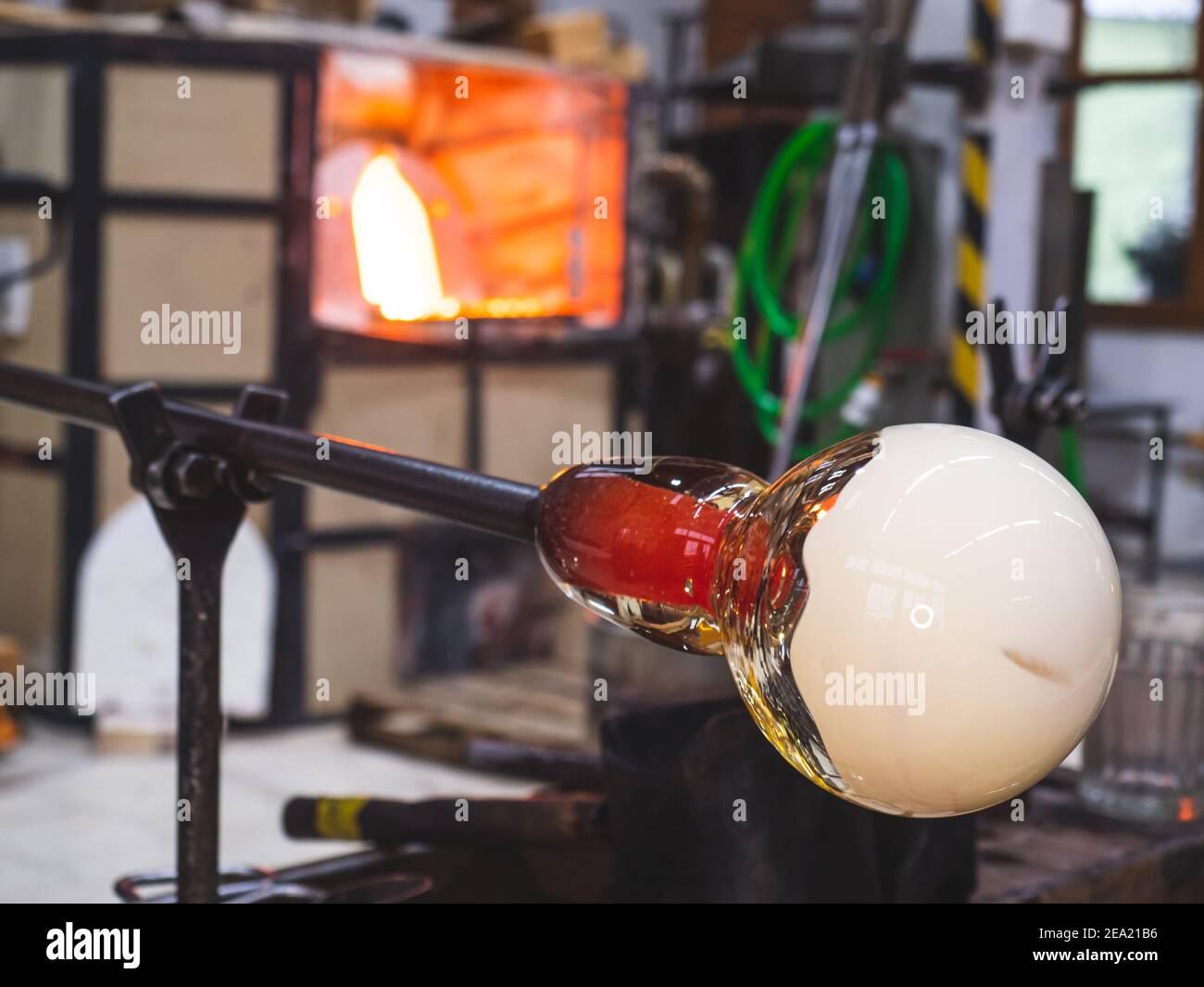 Detail of blowing molten glass into a dish during an art show and ...