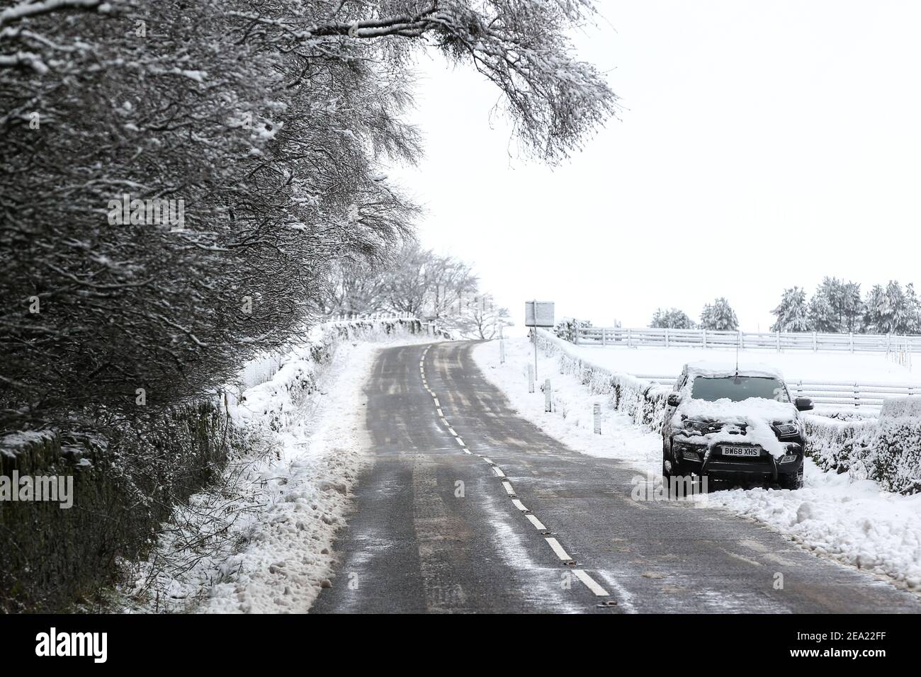 View of a snow-covered car aside the road in Holmfirth.Many areas of ...