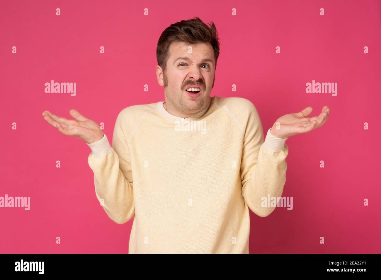 Young confused man shrugging shoulders, spreading hands isolated on ...