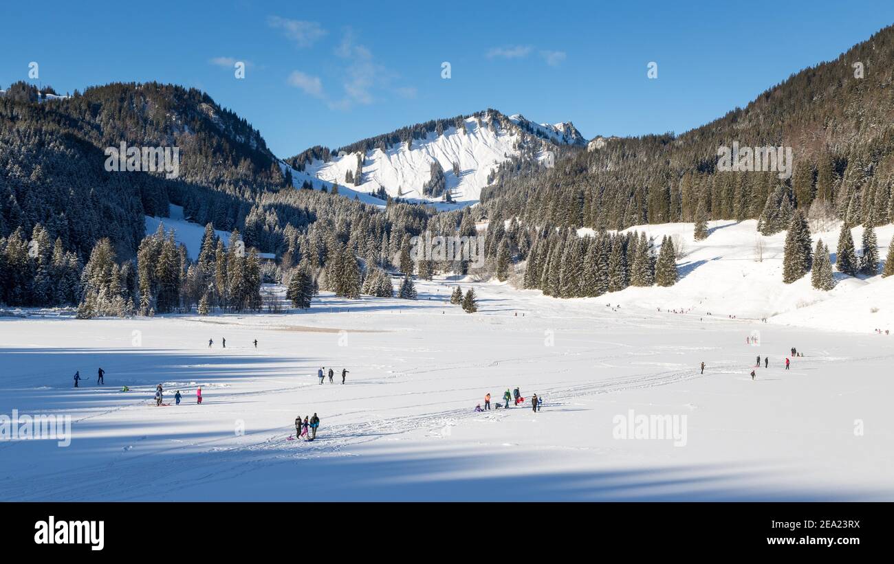 Frozen Spitzingsee in winter with people, in the back Brecherspitz ...