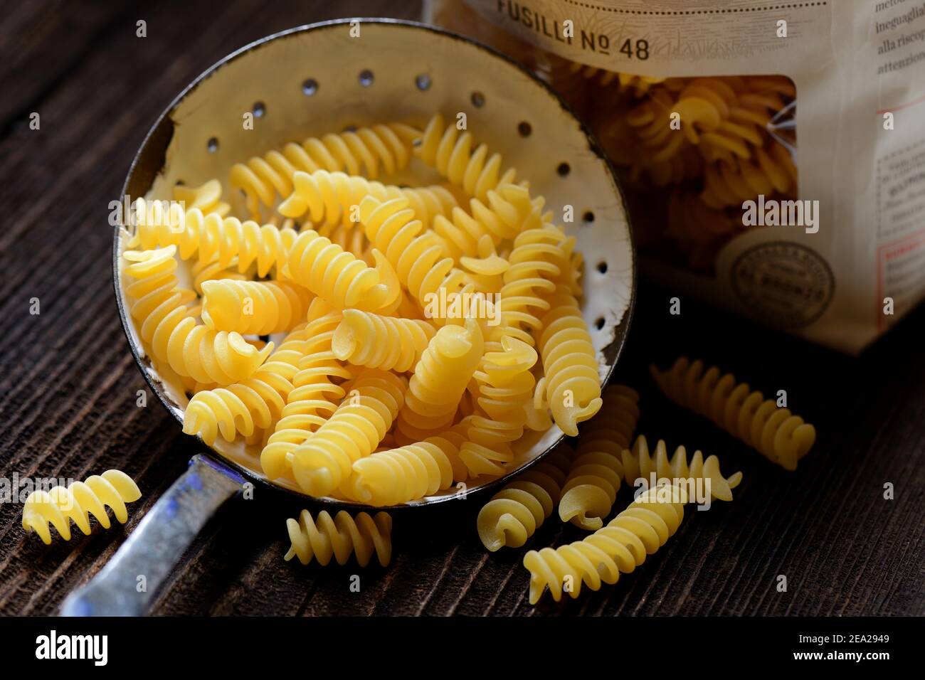 Spiral noodles in sieve ladle, Fusilli, uncooked Stock Photo - Alamy
