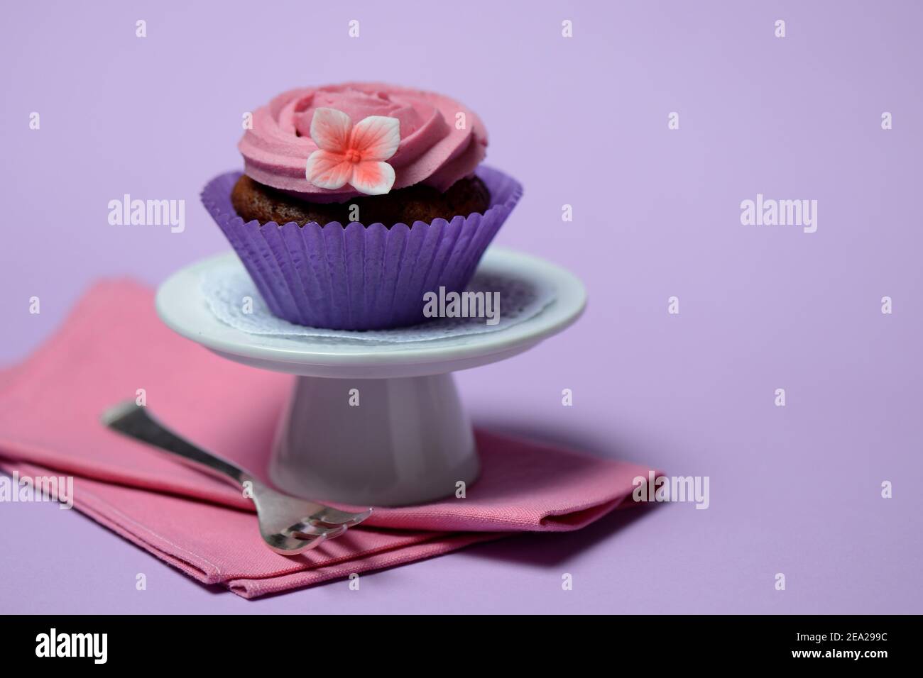 Cupcake on plate with cake fork Stock Photo - Alamy
