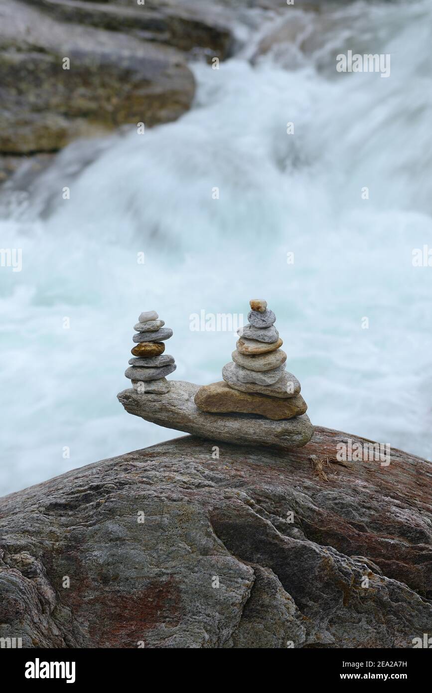 Stacked stones in front of running water, Valle Verzasca, Ticino ...