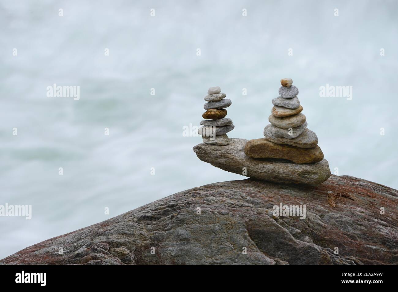 Stacked stones in front of running water, Valle Verzasca, Ticino ...