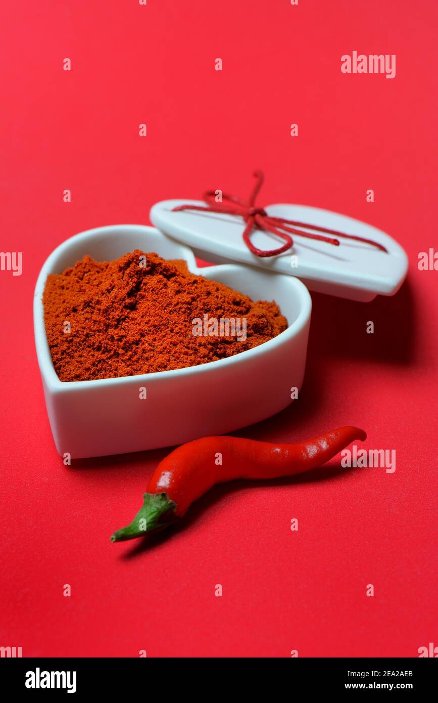 Chili powder in bowl with heart shape, chili peppers( Capsicum annuum ...