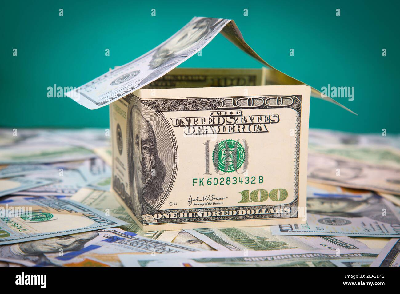 Mortgage concept. House made of dollars banknotes on a green background ...