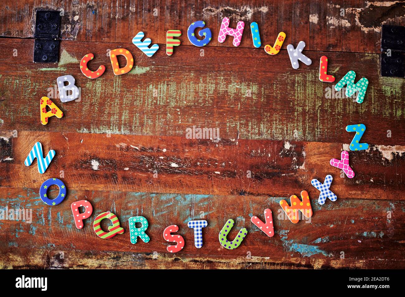 Auburn wooden table with colorful letters that show the alphabet lying ...