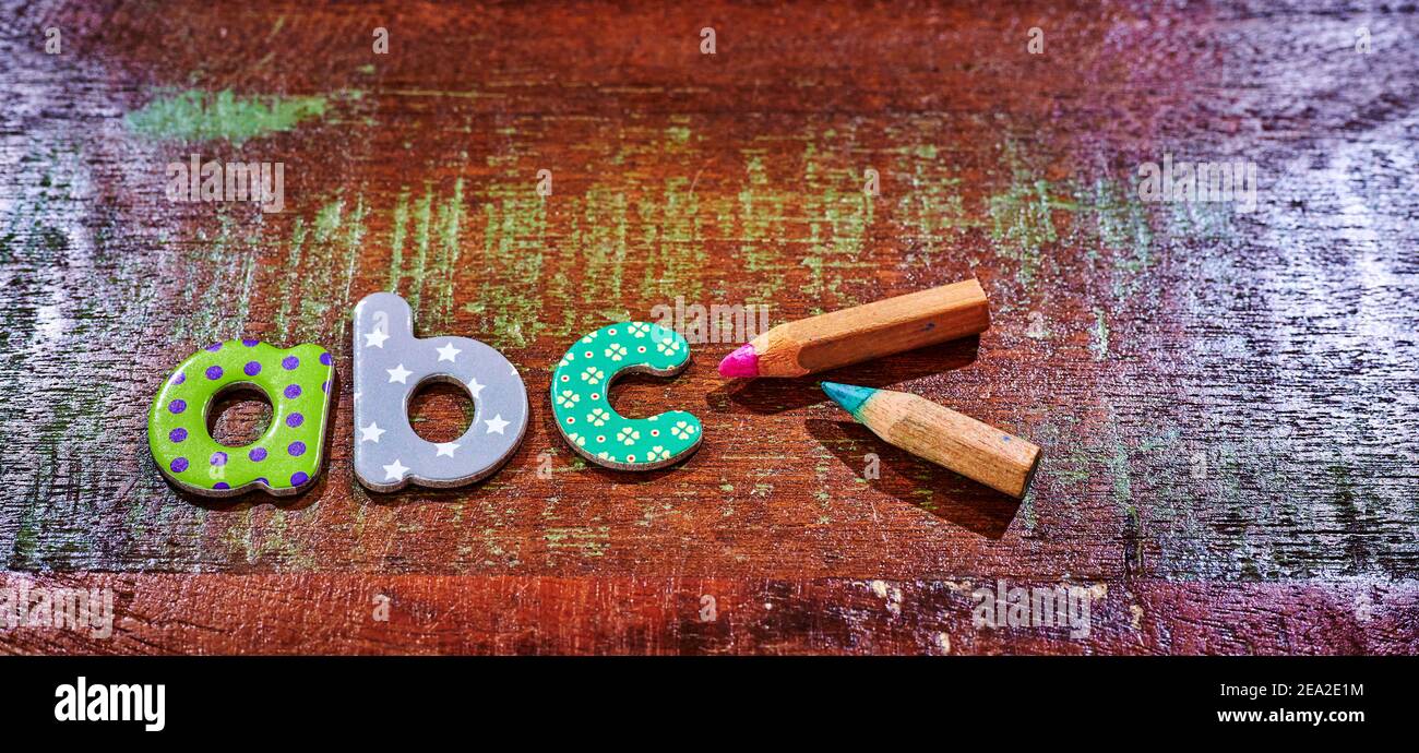 Auburn wooden table with colorful letters that make up the term ABC ...