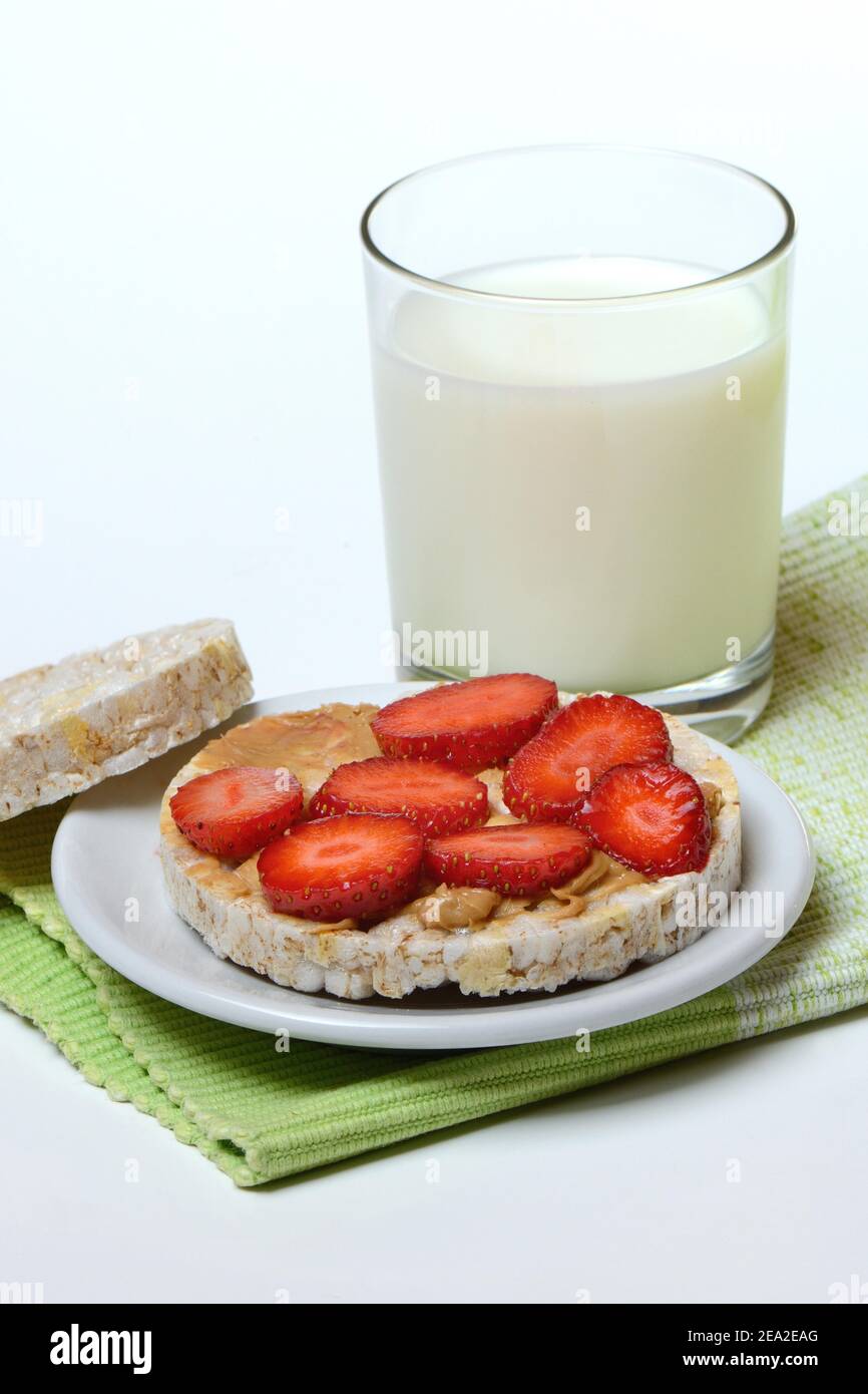 Corn and rice waffle topped with strawberries and peanut butter, glass ...