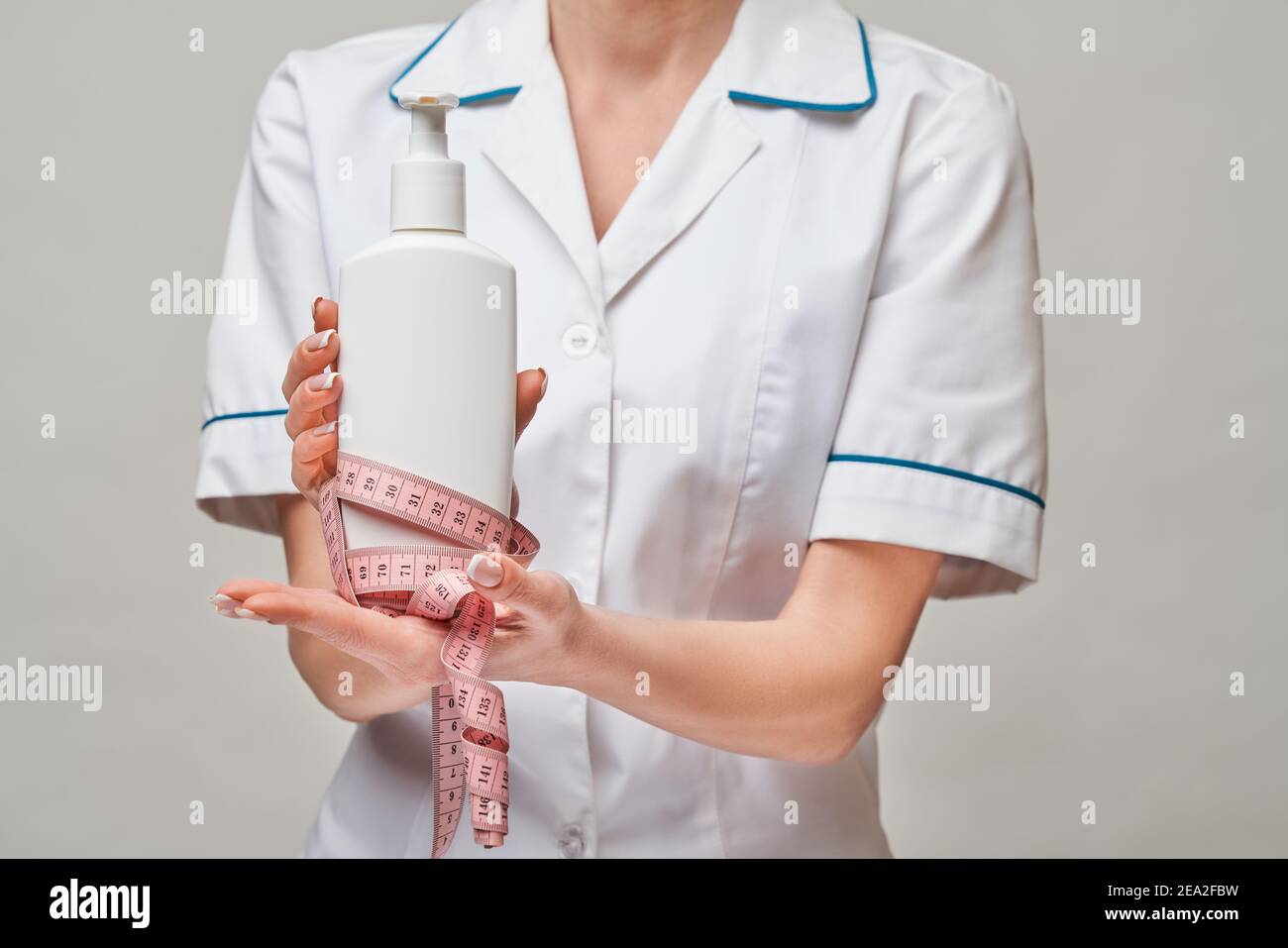 Portrait of beauty specialist standing against grey background and ...