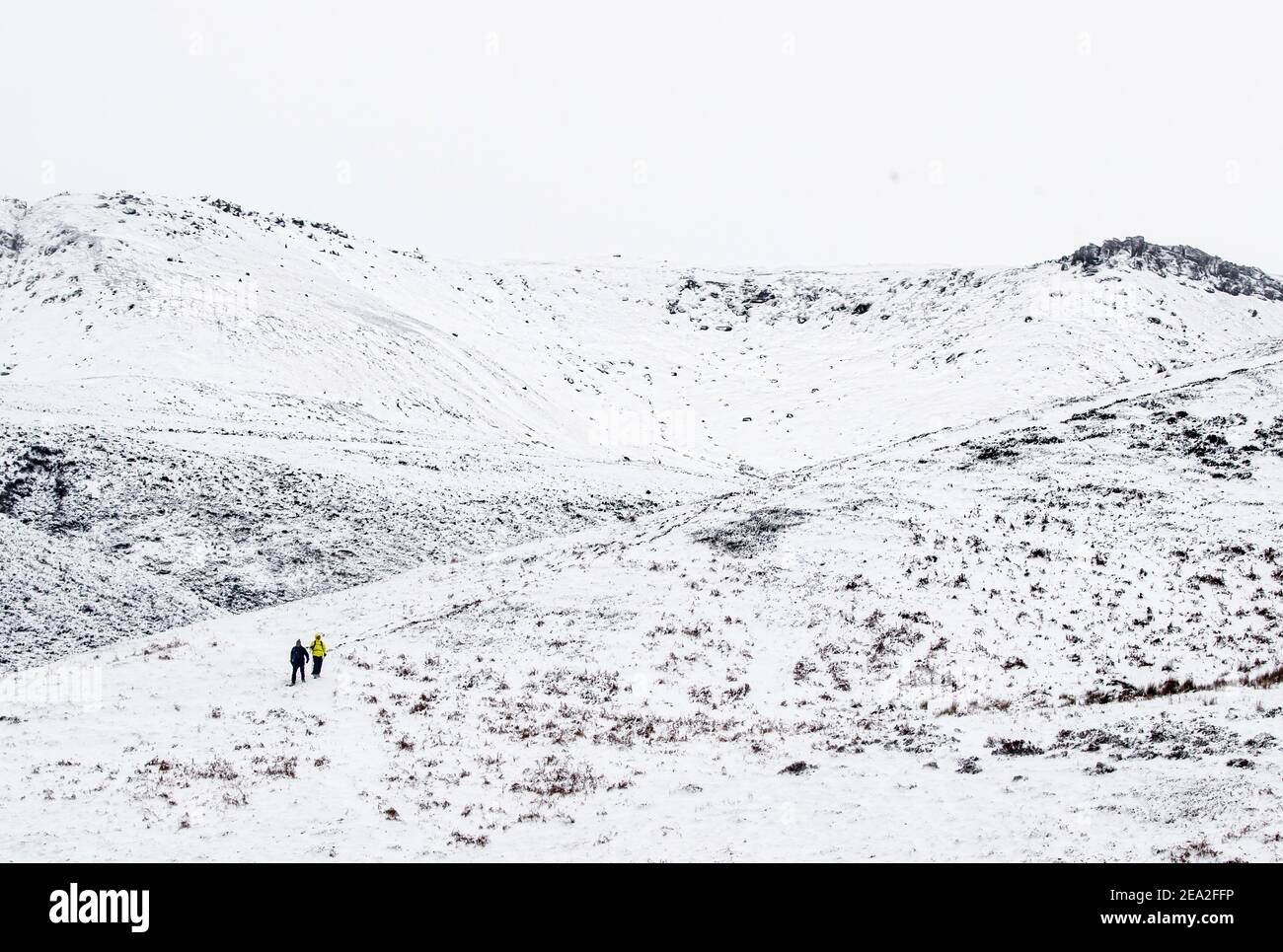 People walk near the Snake Pass in the Peak District, with heavy snow ...