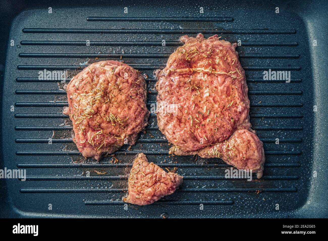 Cooking a raw slice of kobe beef ribeye steak on a raised pan in the ...