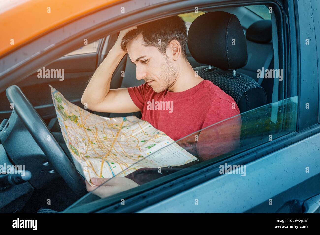 A frustrated man gets lost and tries to find his location on a map ...