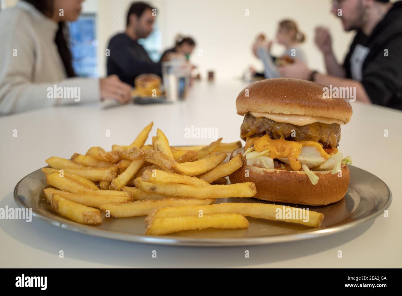 Cheese burger beef and fried potatoes, French fried on metal tray and ...