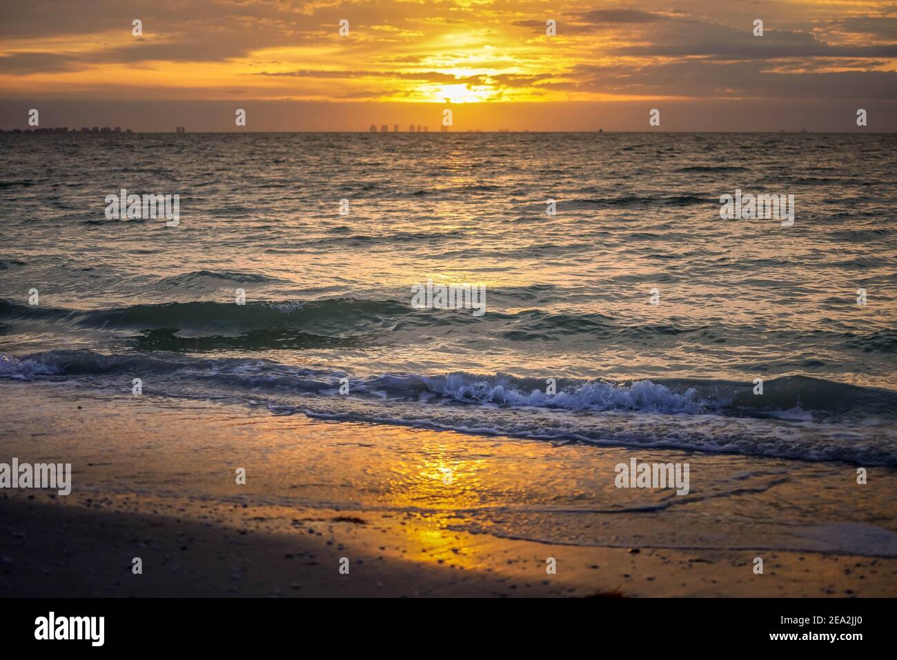 Brilliant sunset over the ocean waves reflecting on the water on the ...