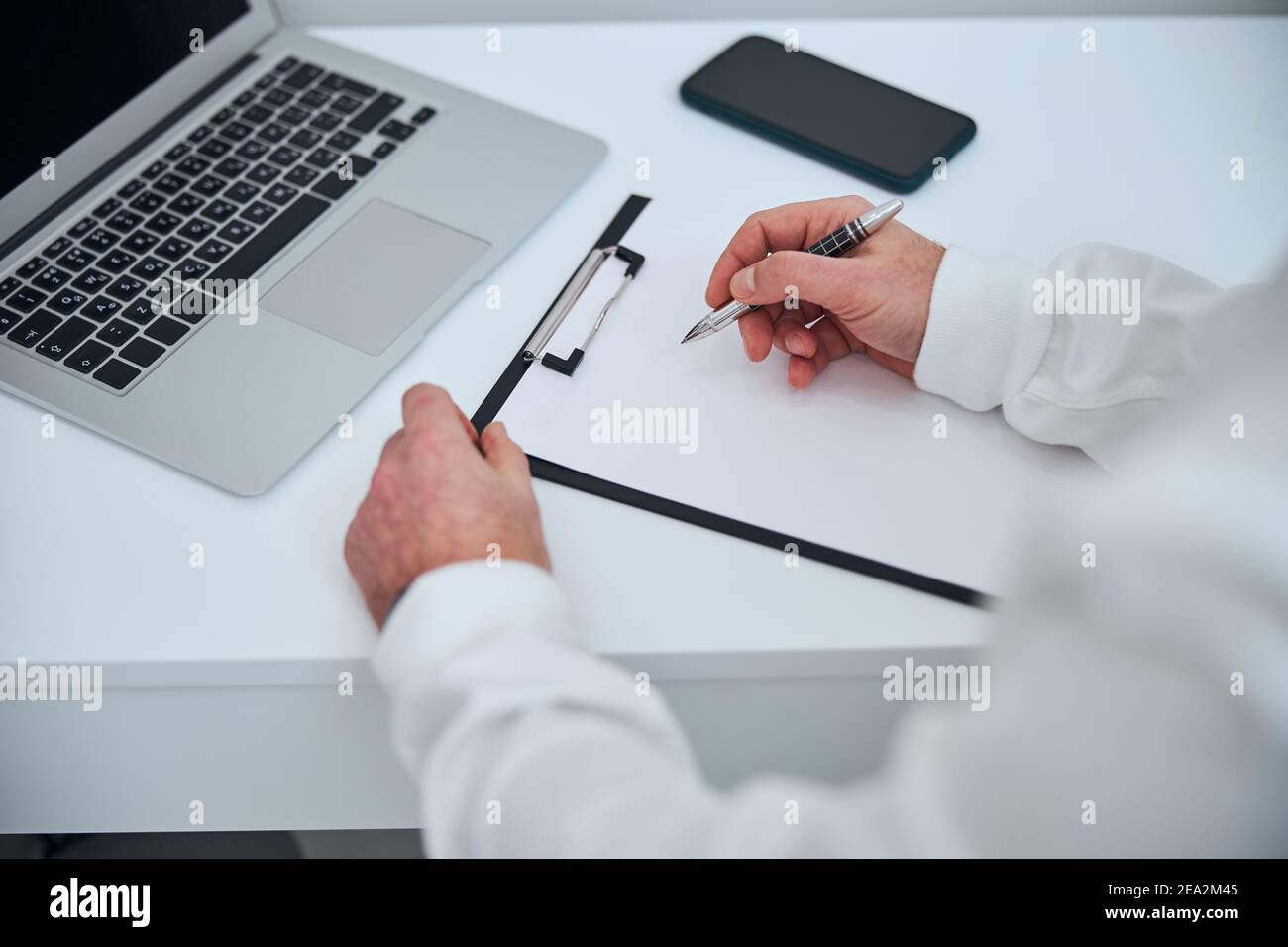 Male doctor using notebook in modern office Stock Photo - Alamy