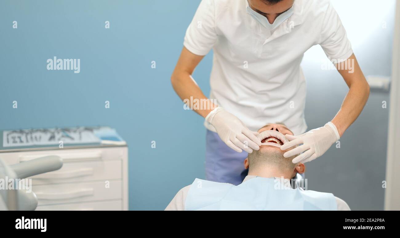 Dentist wearing optragate for the male patient Stock Photo - Alamy
