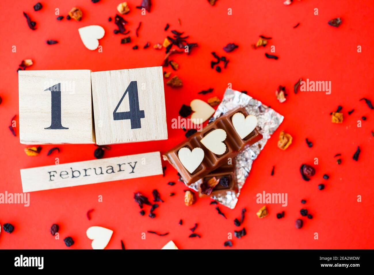 Wooden calendar with the date of February 14 on a bright red background ...
