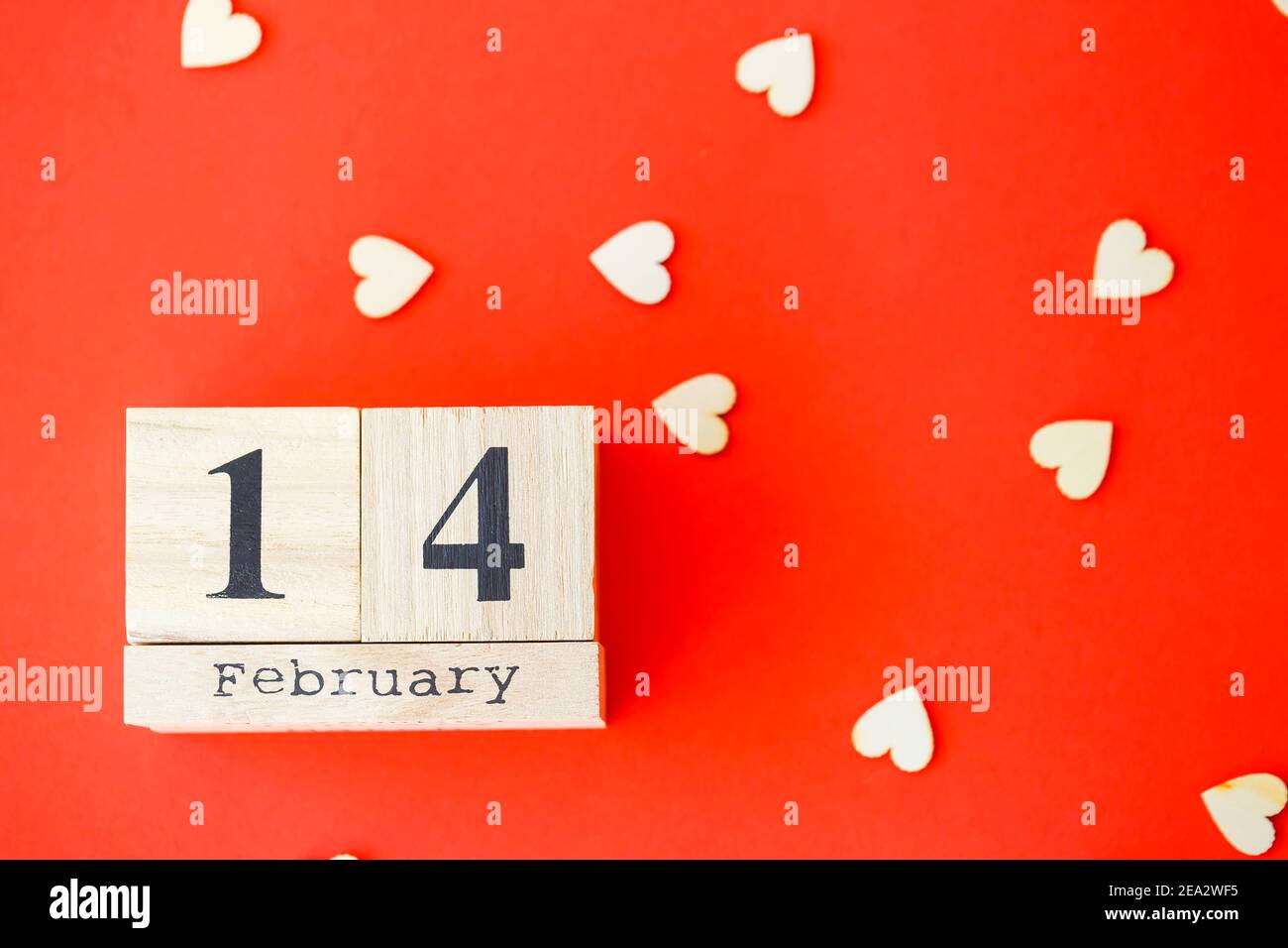 Wooden calendar with the date of February 14 on a bright red background ...
