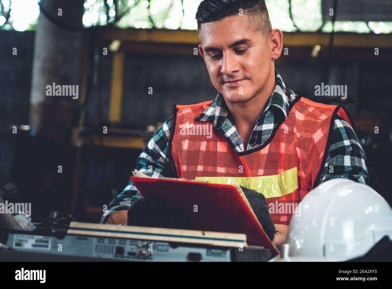 Manufacturing worker working with clipboard to do job procedure ...