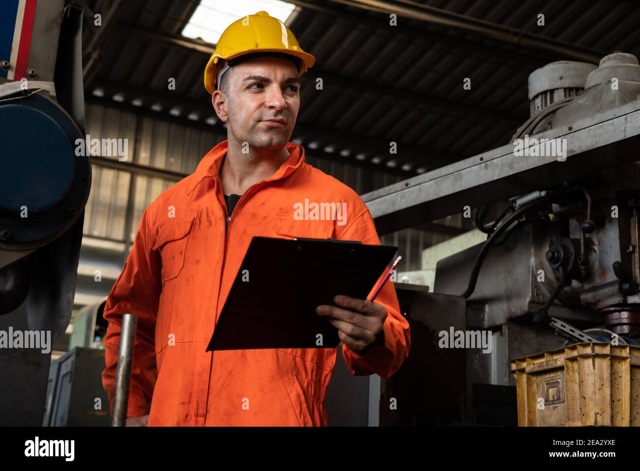 Skillful factory worker working with clipboard to do job procedure ...
